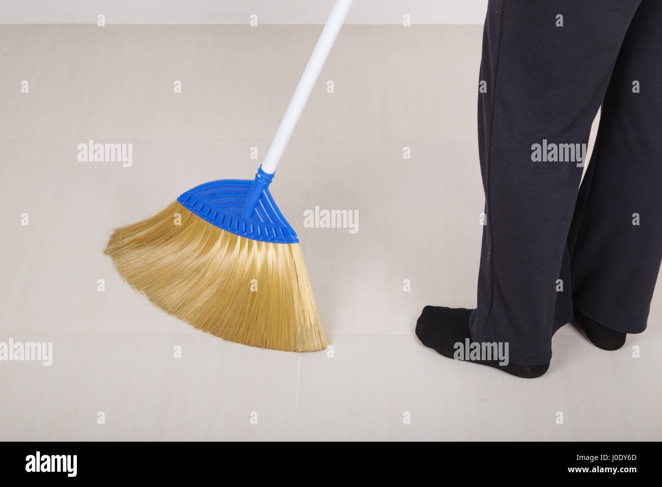 woman legs with broom sweeping the floor Stock Photo - Alamy