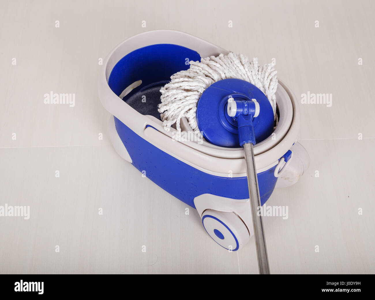 mop and blue bucket for cleaning the floor Stock Photo - Alamy