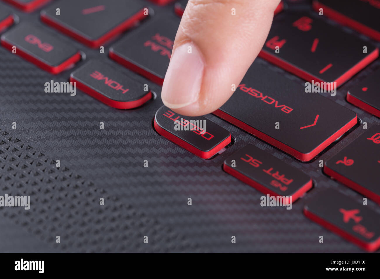 finger pushing delete button on a laptop keyboard Stock Photo - Alamy