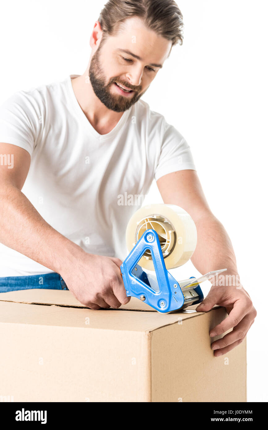 Young bearded man packing cardboard box on white Stock Photo - Alamy