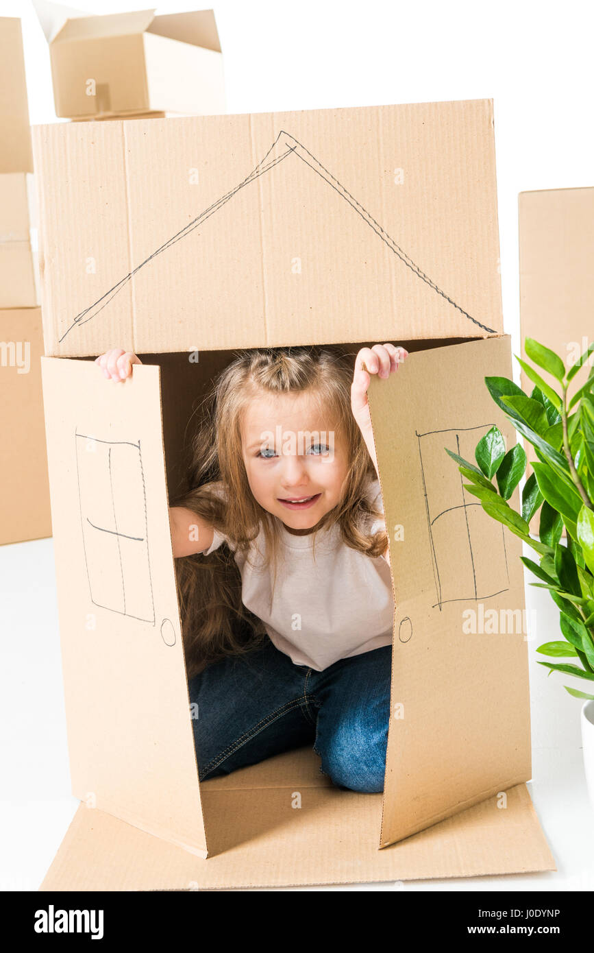 Cute little girl sittling inside of cardboard box with house drawed on ...