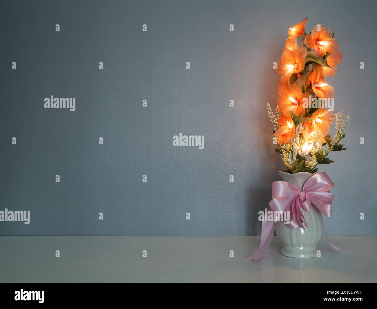 electric flower in vase on table with wall background Stock Photo - Alamy