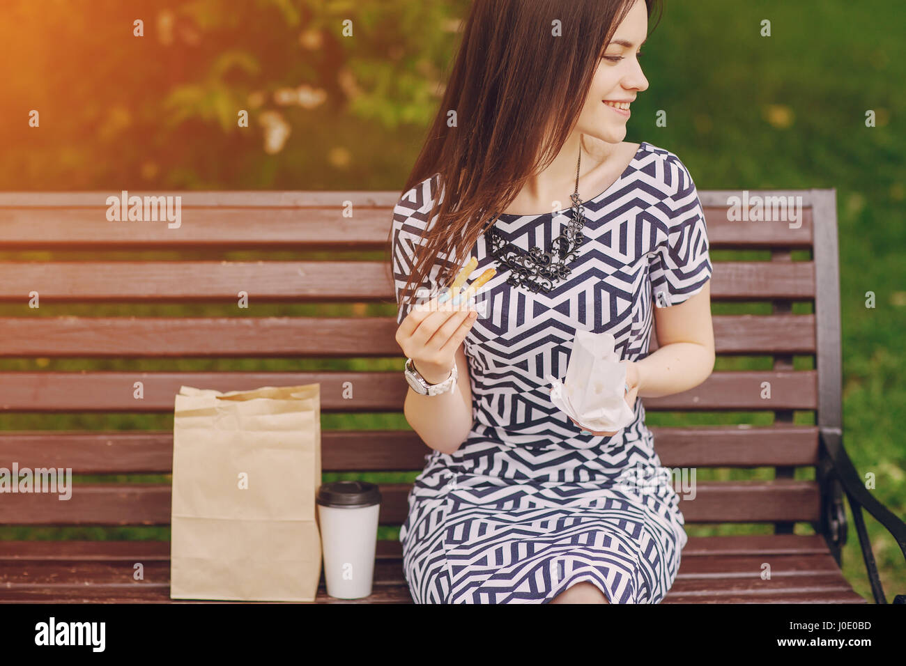 young model enjoying the break and eating fries Stock Photo - Alamy