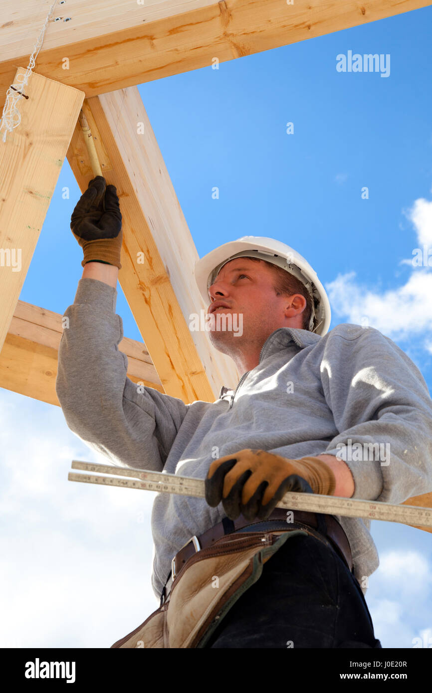 carpenter at work with wooden roof construction Stock Photo - Alamy