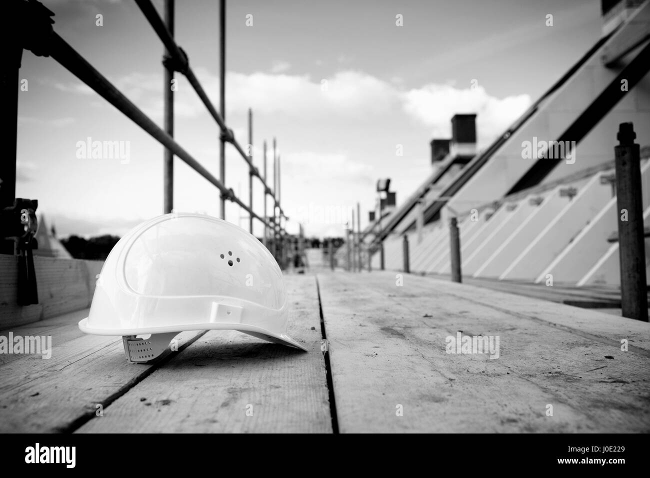 empty building site with left helmet on scaffold Stock Photo - Alamy
