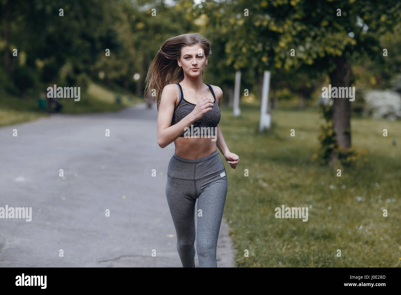 athletic girl running in the Park and doing exercises Jogging Stock ...