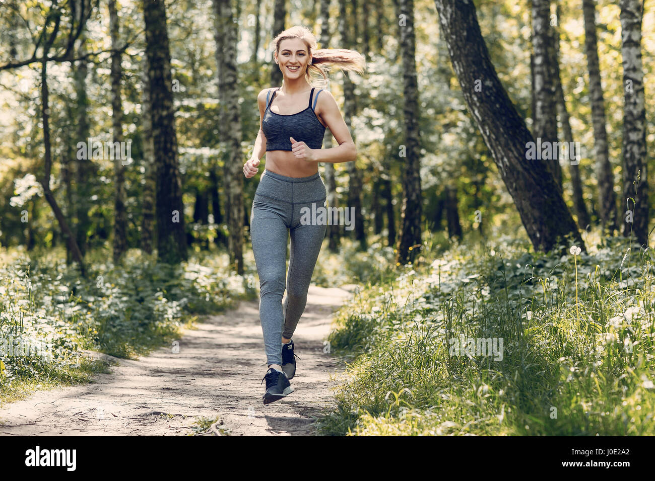 athletic girl running in the Park and doing exercises Jogging Stock ...
