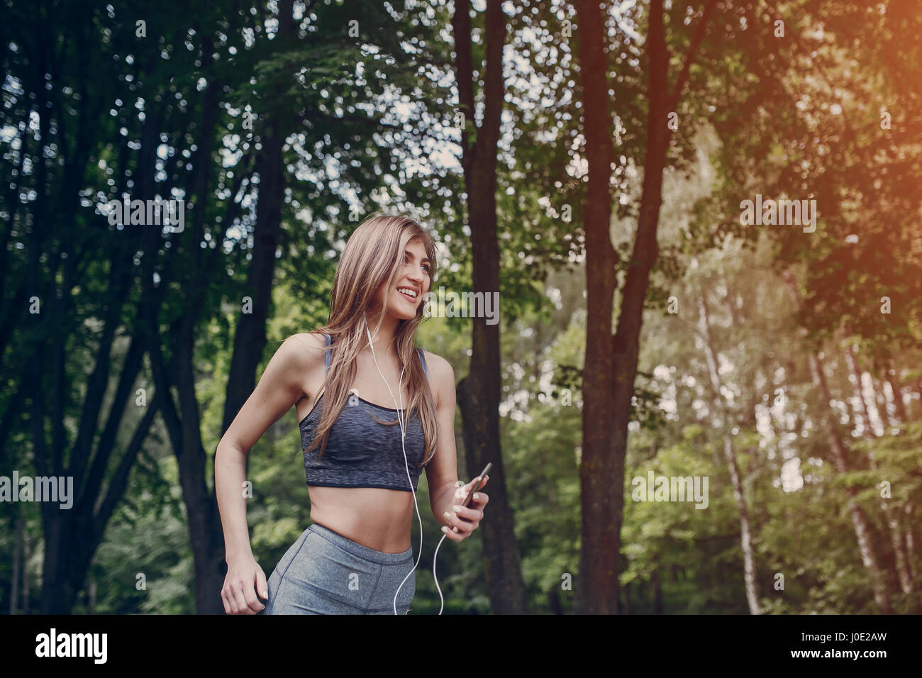 athletic girl running in the Park and doing exercises Jogging Stock ...