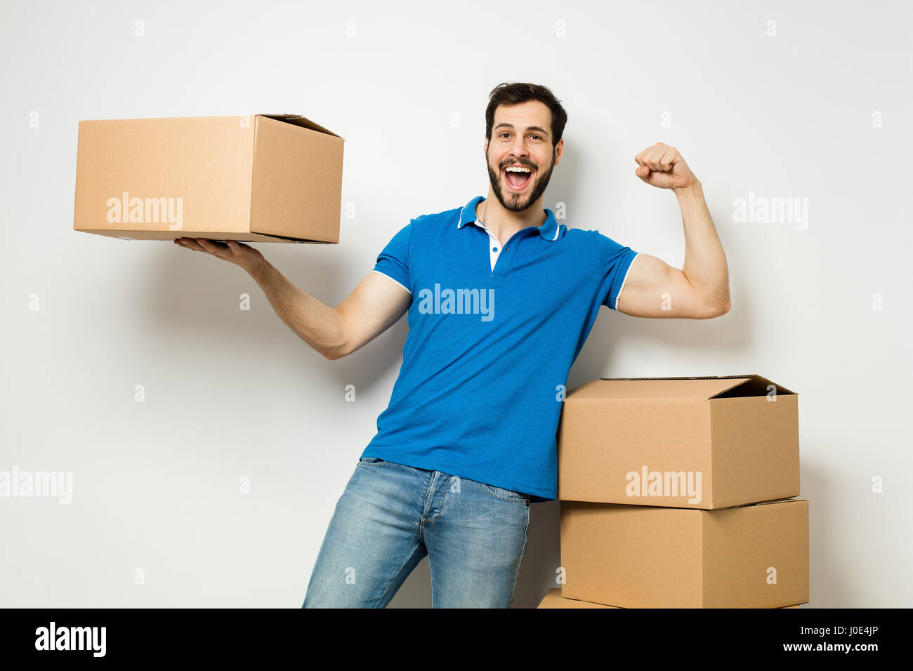 strong man showing his muscles next to a stack of cardboard boxes Stock ...