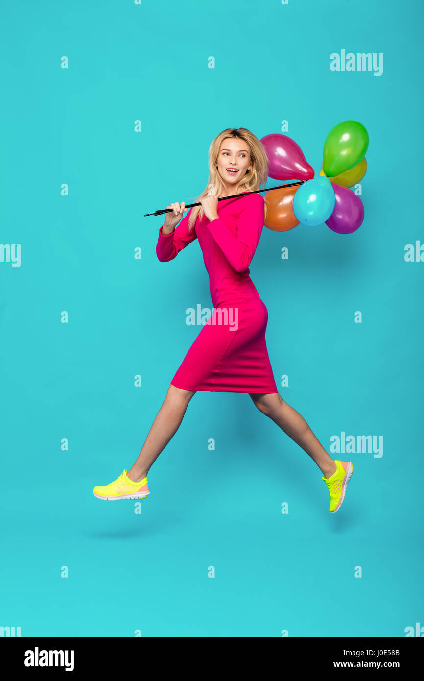 beautifull blonde woman very energetic, smiling and jumping with some ...