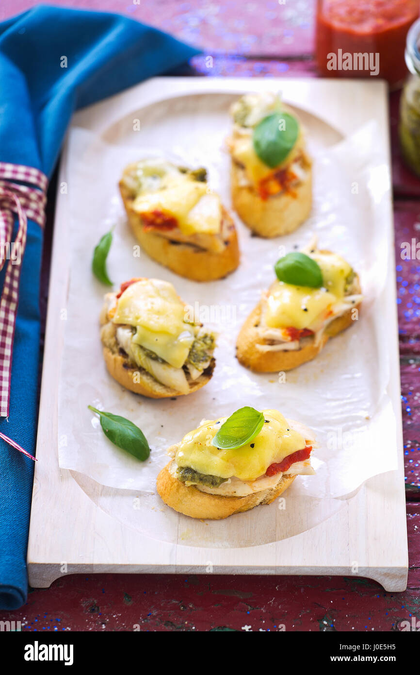 Italian chicken crostini with cheese and basil Stock Photo - Alamy