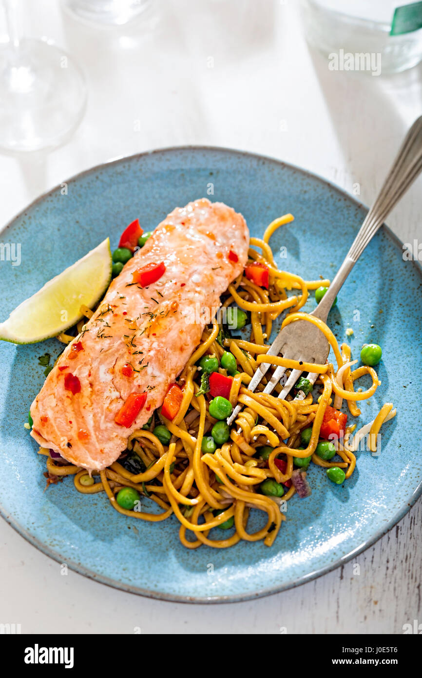 Chilli salmon with pasta and vegetables and lime wedge Stock Photo - Alamy