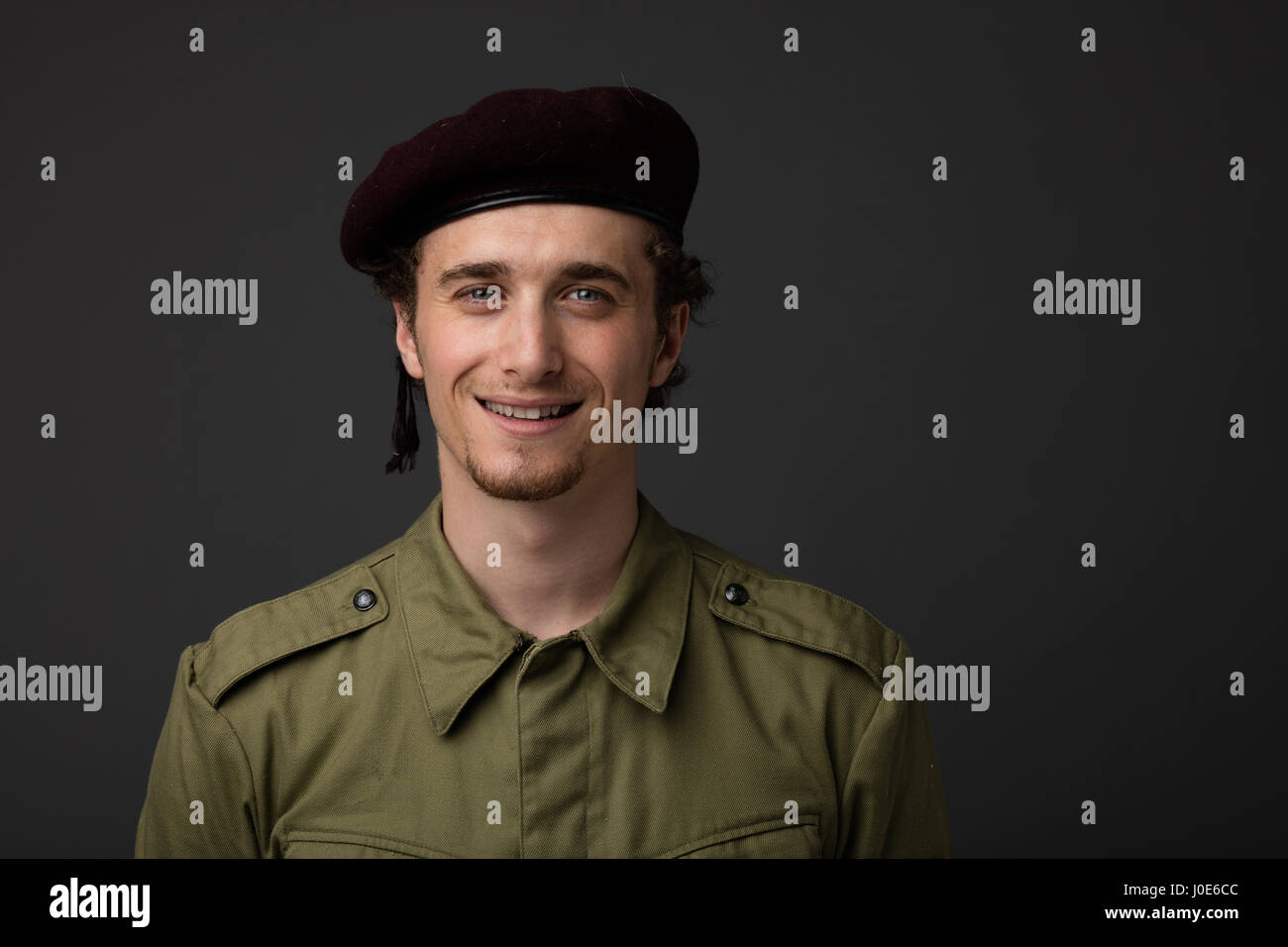 young military with red beret and green uniform on gray background ...