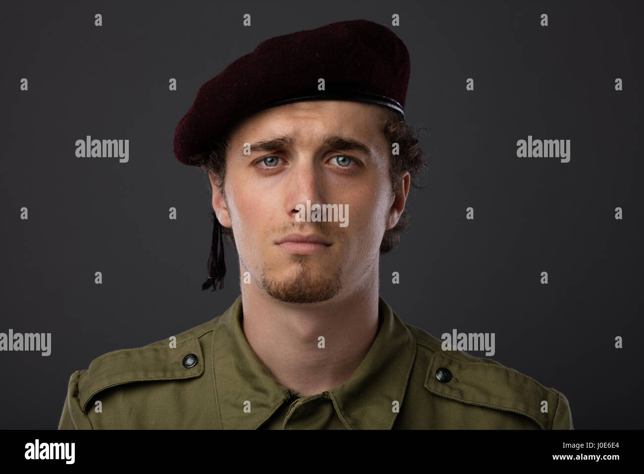 young military with red beret and green uniform on gray background ...
