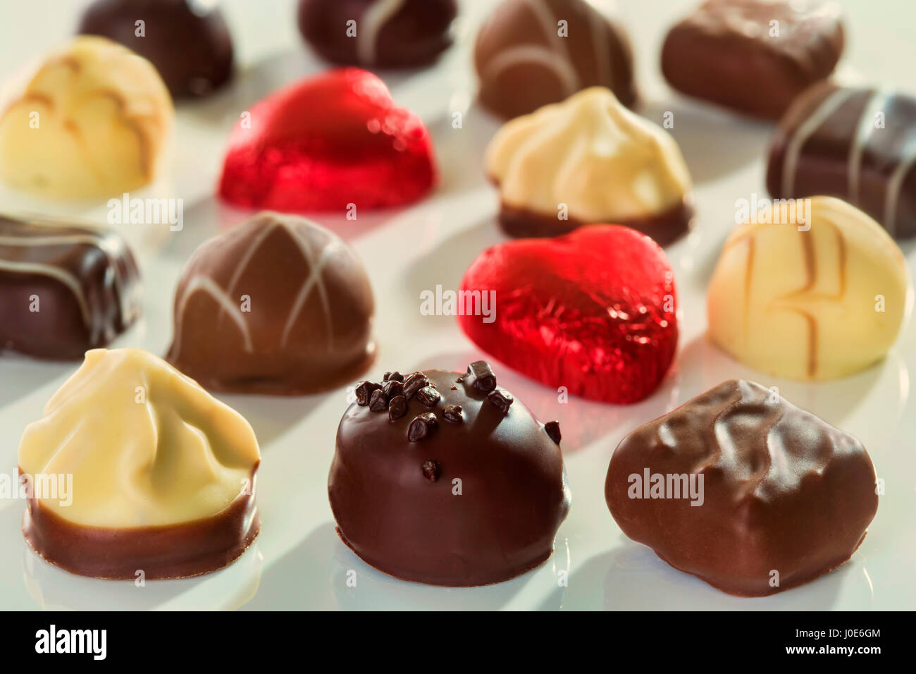 Sweet chocolate pralines on white background Stock Photo - Alamy
