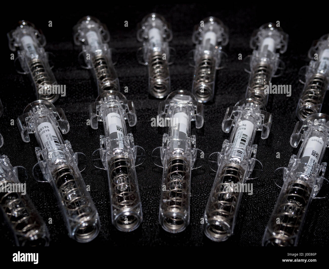 Arrayed on a dark background these syringes are used to deliver ...