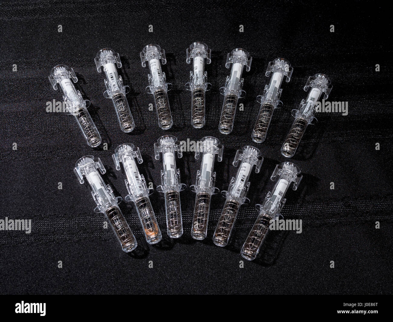 Arrayed on a dark background these syringes are used to deliver ...