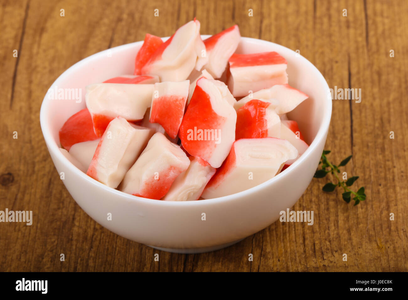 Crab stick - surimi in the plate - over wood background Stock Photo - Alamy