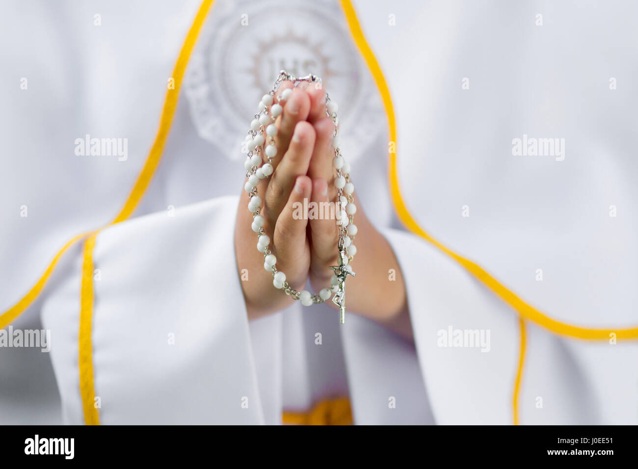First Holy Communion concept - close up on rosary on child's hands ...