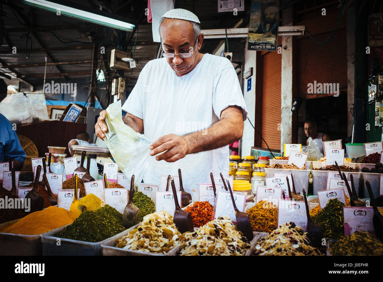 A market salesman is filling up fresh and colourful spices at his spice ...