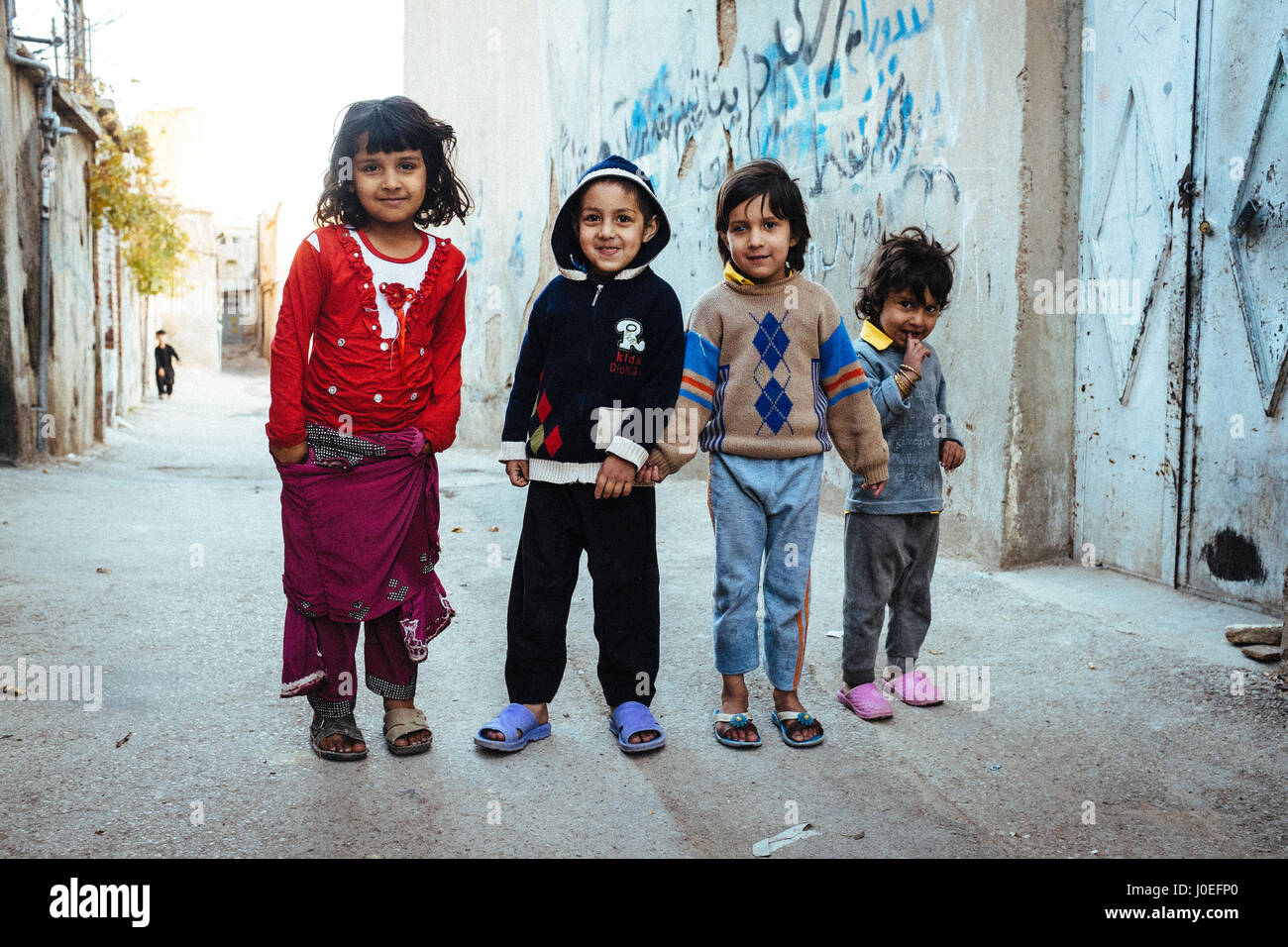 Smiling local children playing at a street in Shiraz, Iran Stock Photo ...