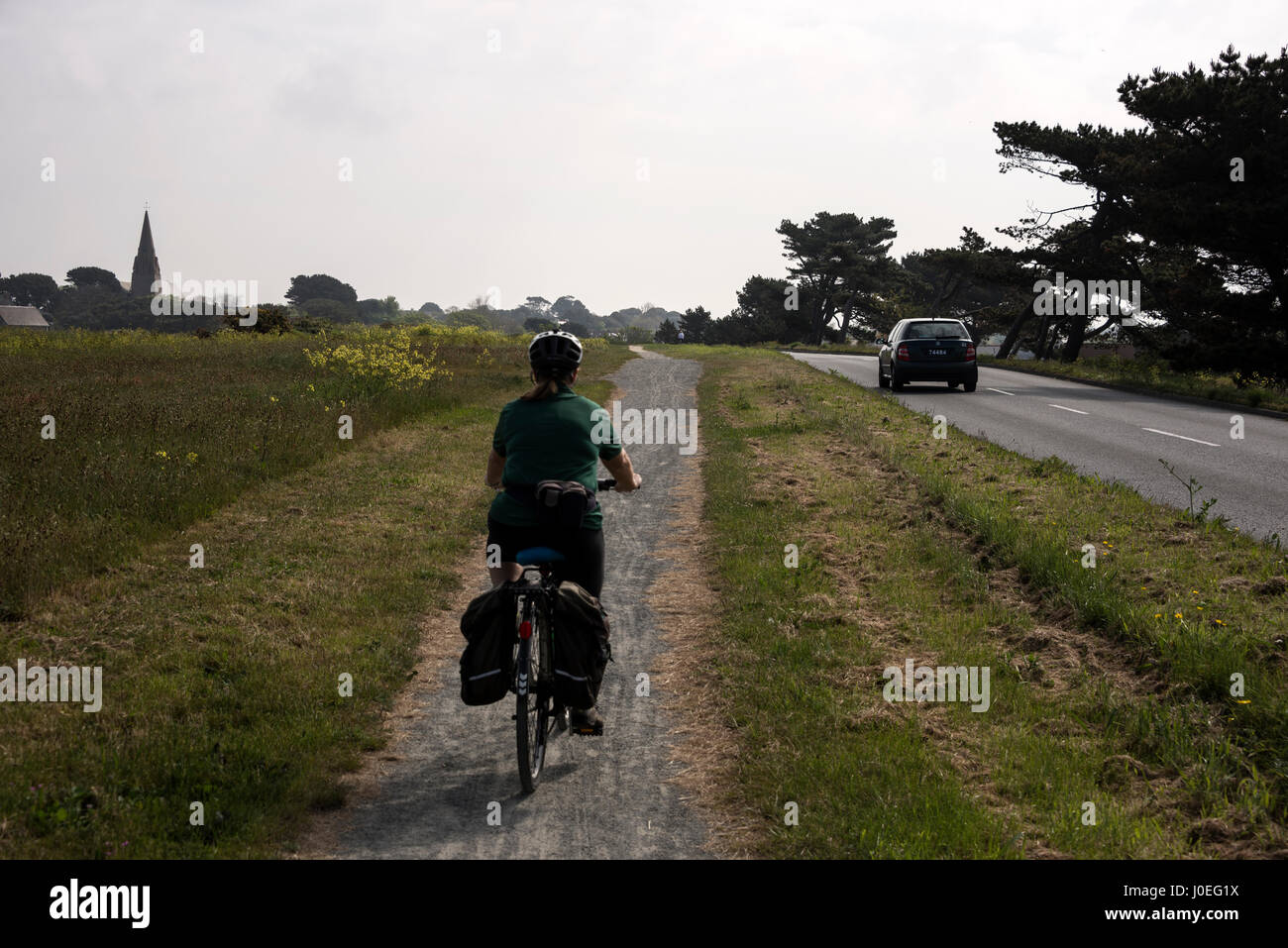 A cyclist riding her bicycle along a pedestrian/ cycle track beside a ...