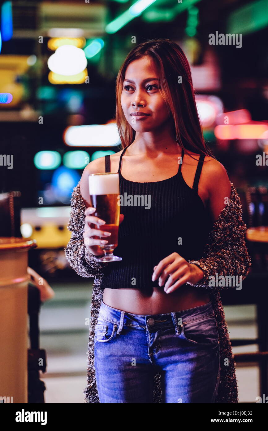 Young beautiful woman drinking beer in a bar Stock Photo - Alamy