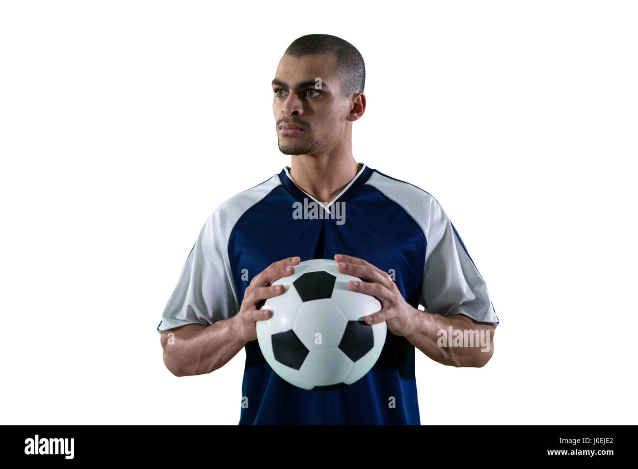 Football player holding football with both hands against white ...
