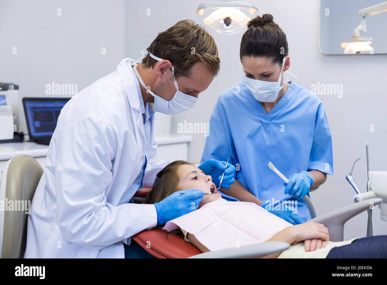 Dentist examining a young patient with tools in dental clinic Stock ...