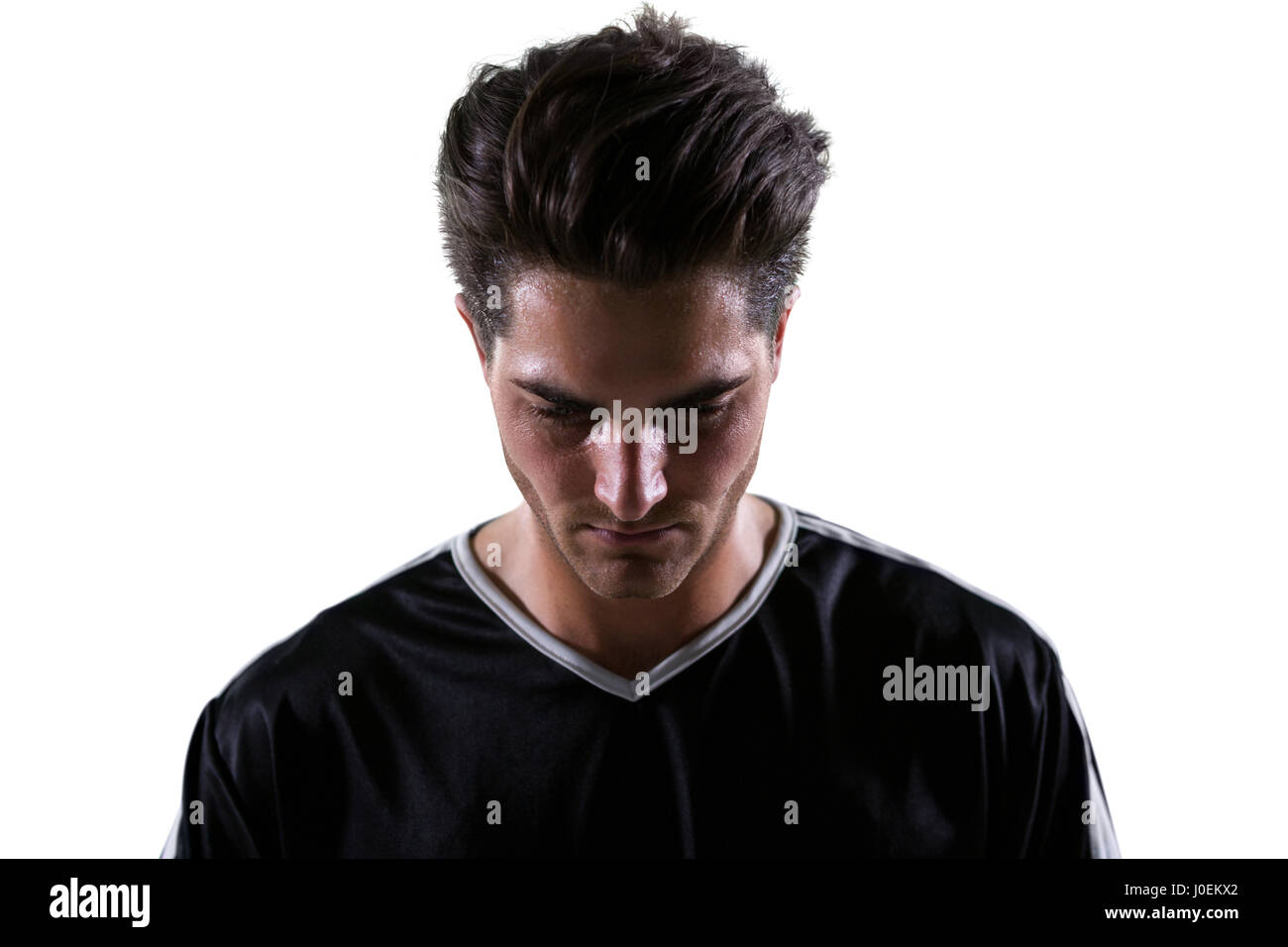 Upset football player looking down against white background Stock Photo ...