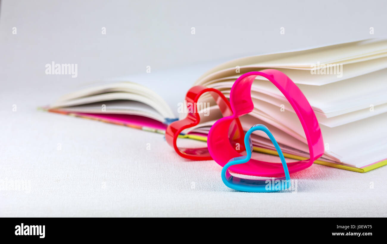 Red lilac and blue hearts laying behind an open diary book Stock Photo ...