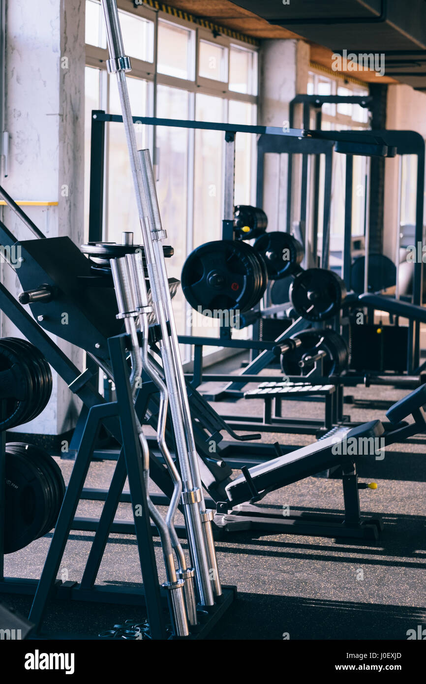 Set of metal barbells disks and bars on barbbell holder in the fitness ...