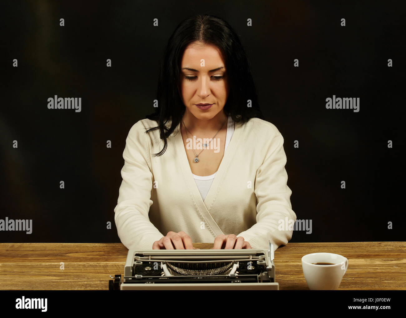 Woman writing on a typewriter Stock Photo - Alamy