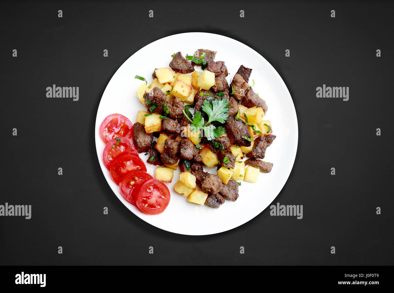 fried liver cubes with potatoes and tomatoes Stock Photo - Alamy