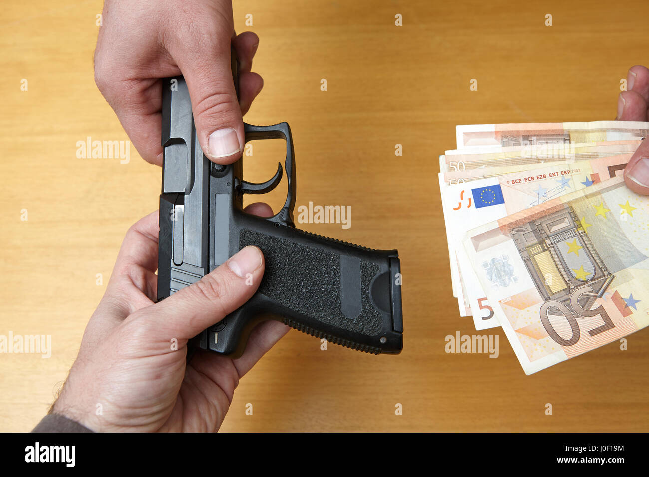 Hands of two men exchange money for a gun Stock Photo - Alamy