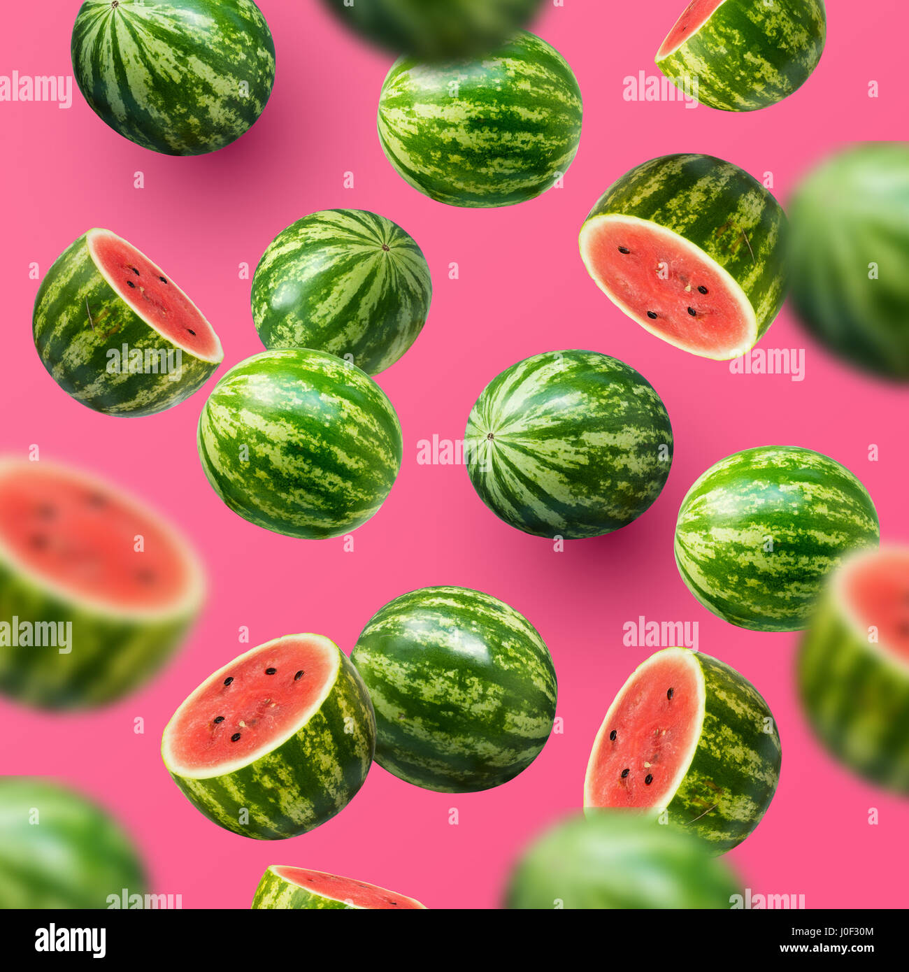 Delicious and juicy sweet watermelons sliced and whole on a pink summer ...