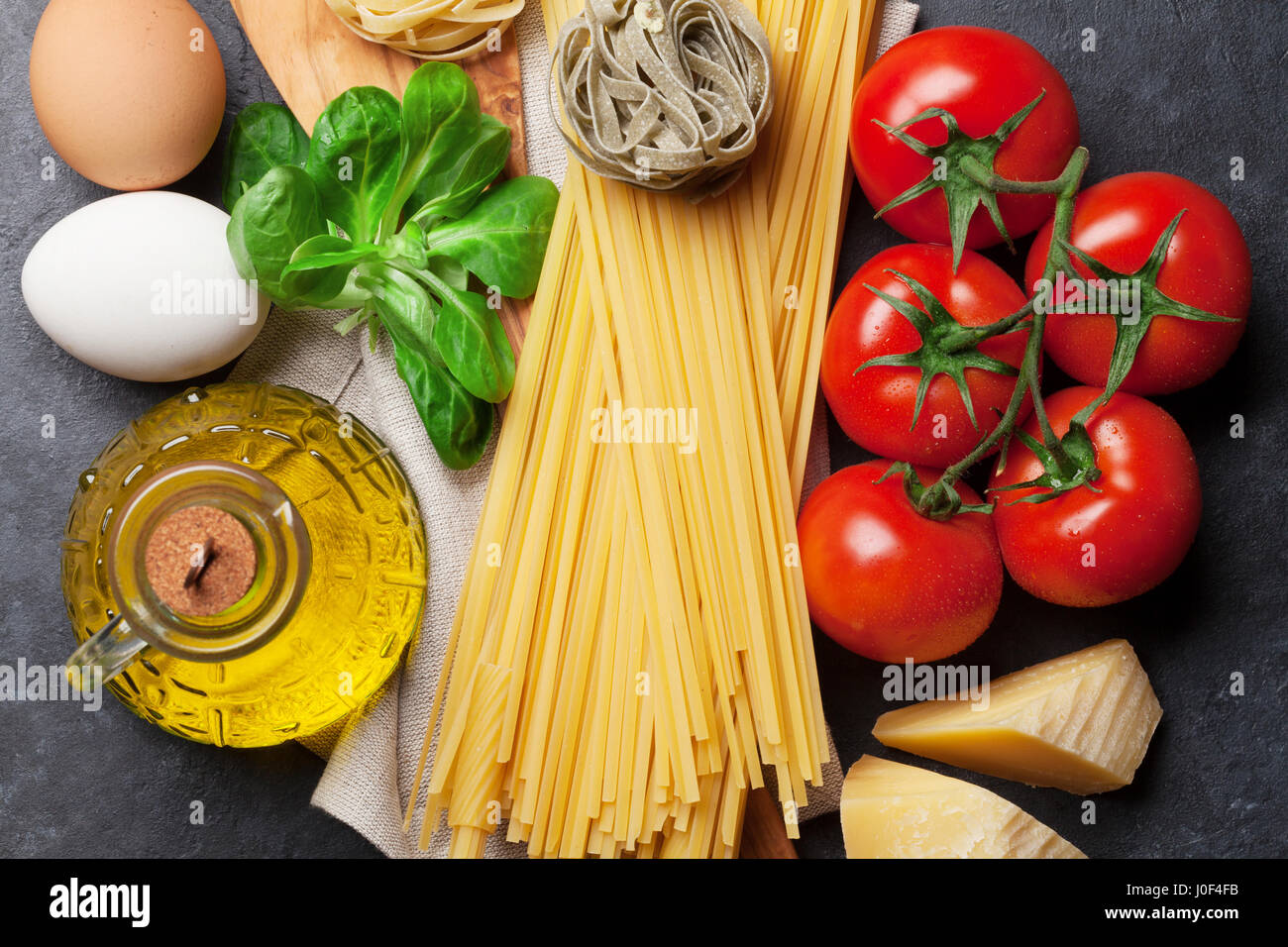Pasta and ingredients on stone table. Top view Stock Photo - Alamy