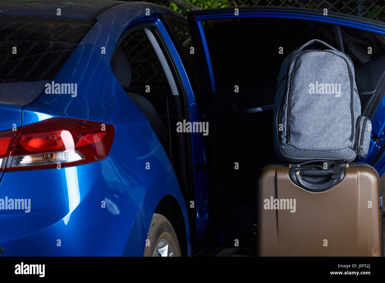 Loading luggage in modern blue car with open back door Stock Photo - Alamy