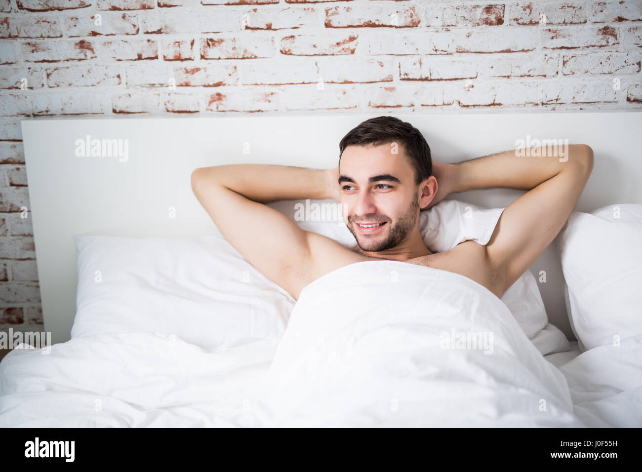 Handsome well built man resting in his bed Stock Photo - Alamy