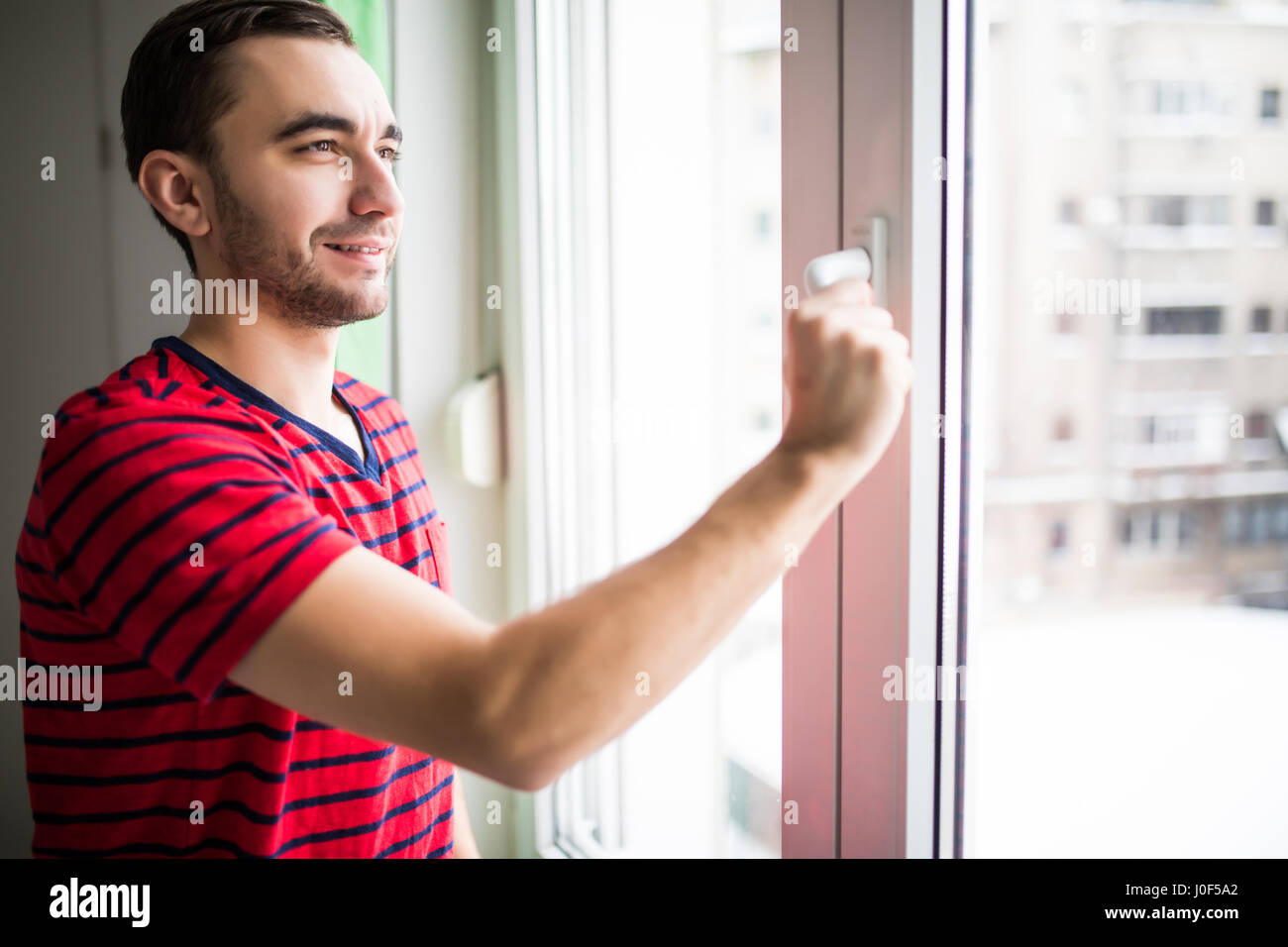 Man is opening the window at home to refresh the room Stock Photo - Alamy