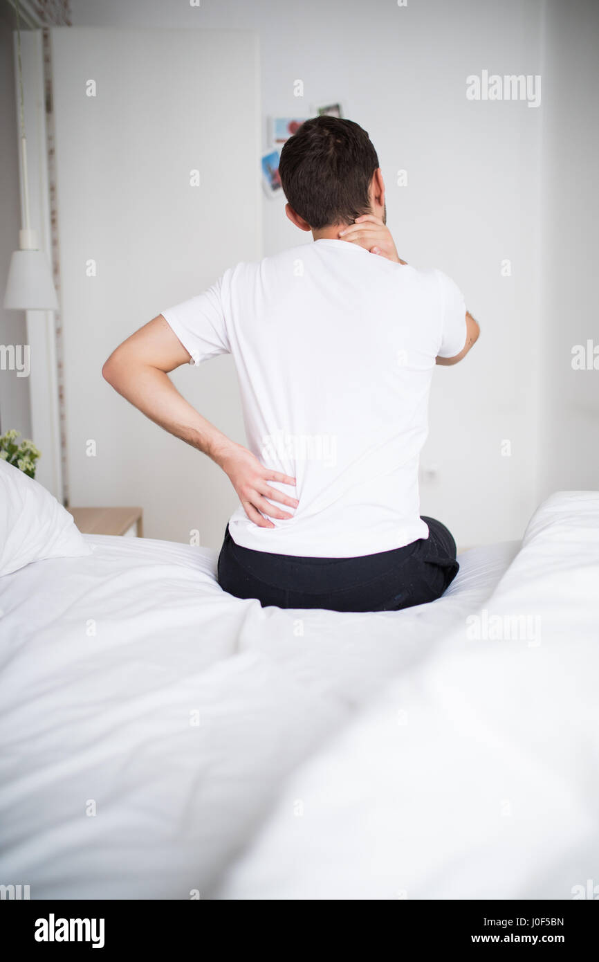 Man suffering from back pain at home in the bedroom Stock Photo - Alamy