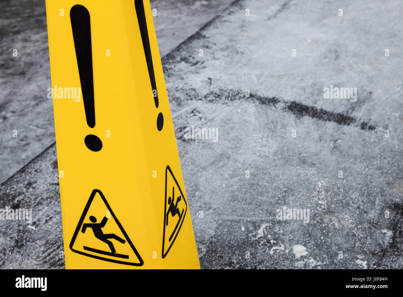 Caution wet floor, yellow warning sign stands on gray asphalt urban ...