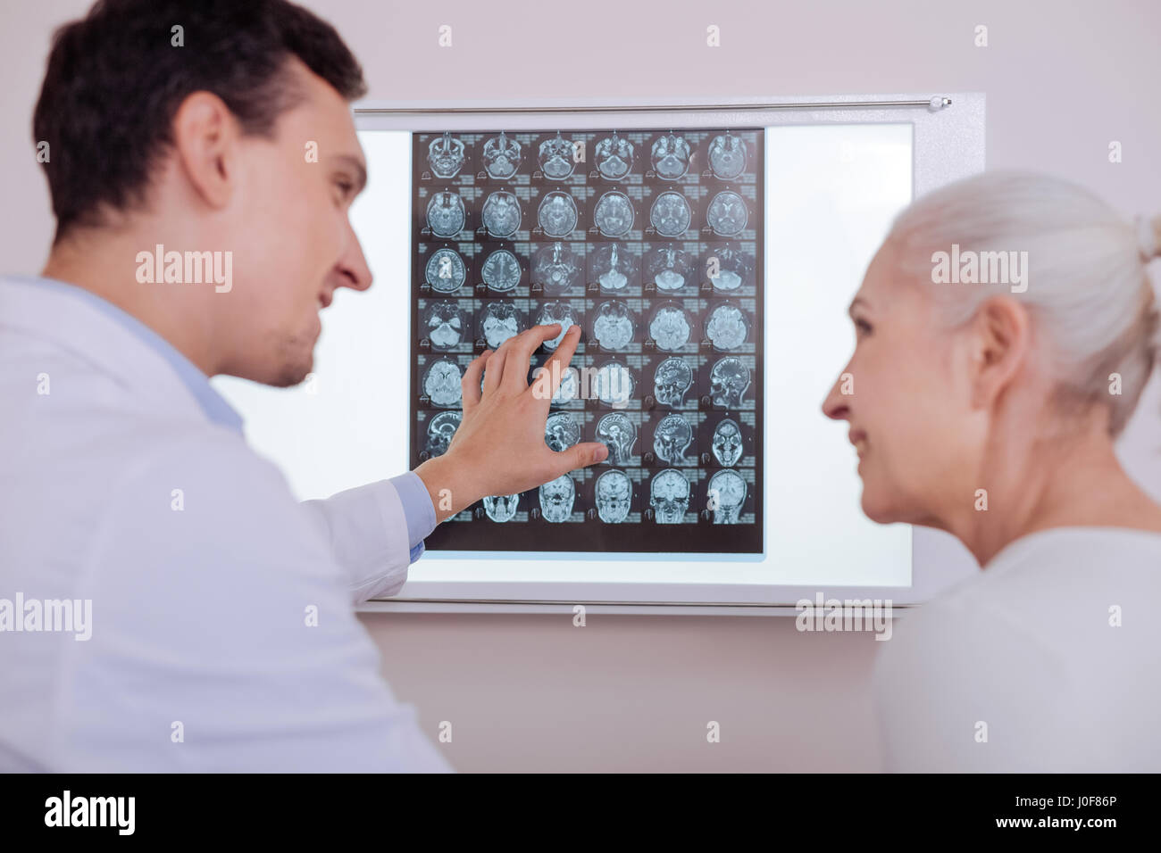 Delighted positive doctor looking at his patient Stock Photo - Alamy