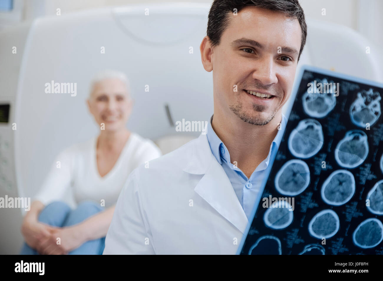 Happy positive doctor holding CT scan results Stock Photo - Alamy