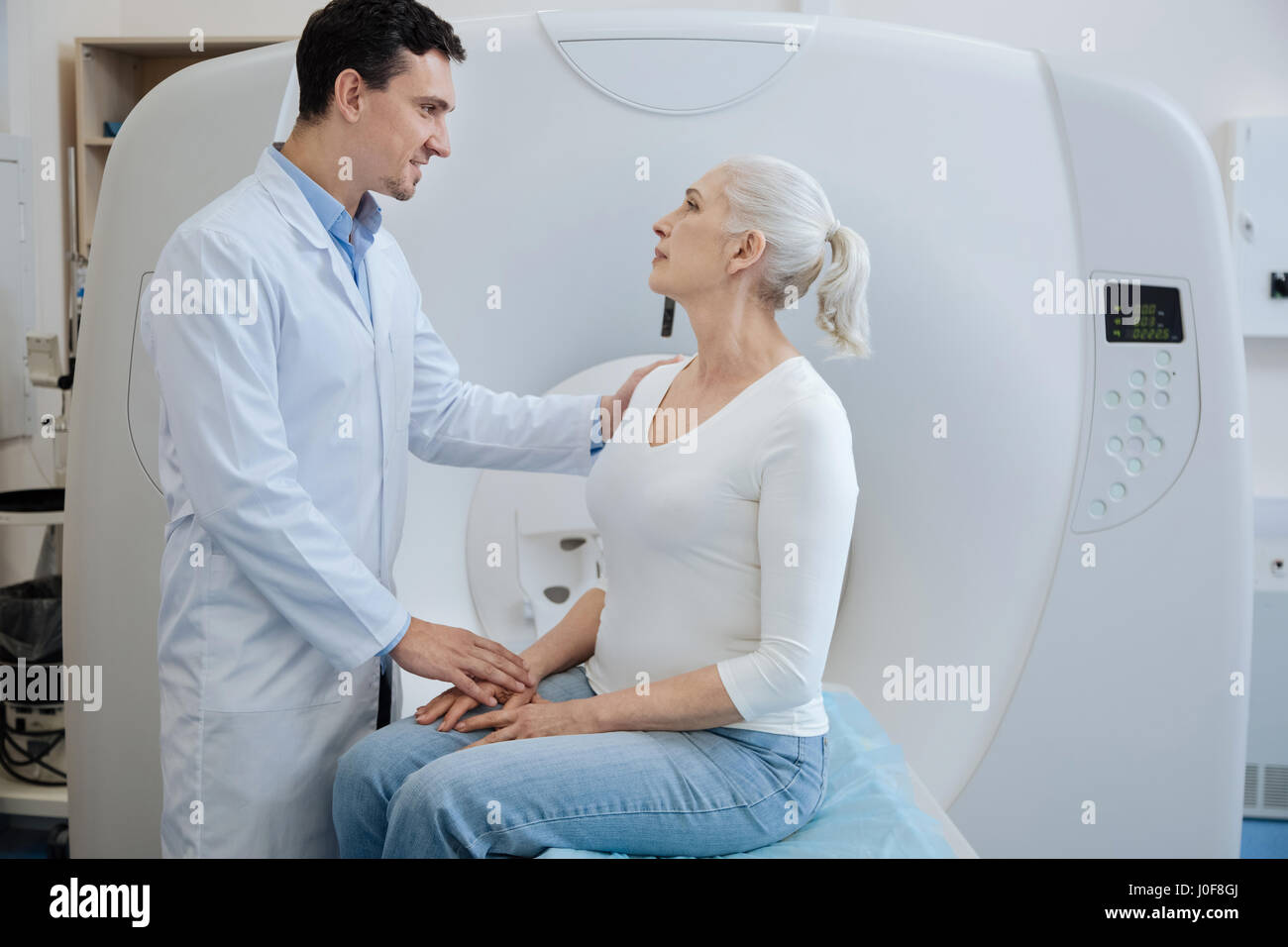 Handsome joyful doctor telling his patient a diagnosis Stock Photo - Alamy