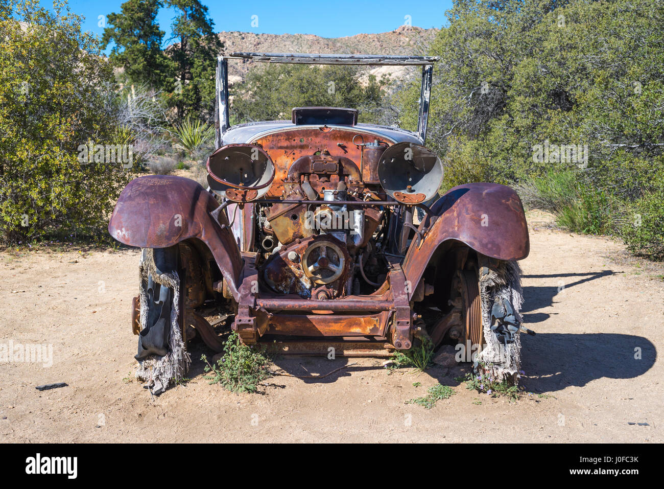 Close up of an old, abandoned car in the desert. Joshua Tree National ...