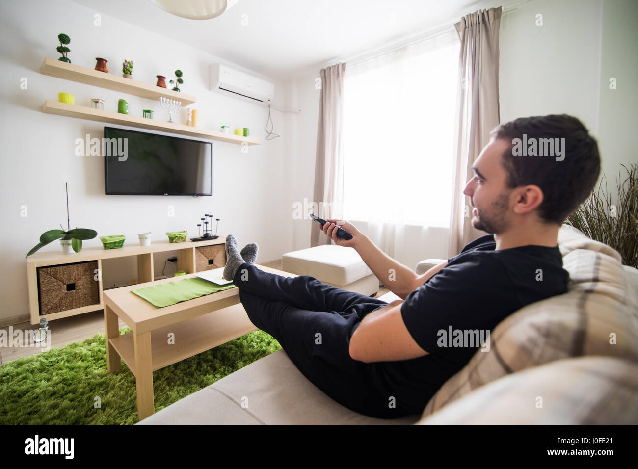 Man watching tv at home hi-res stock photography and images - Alamy