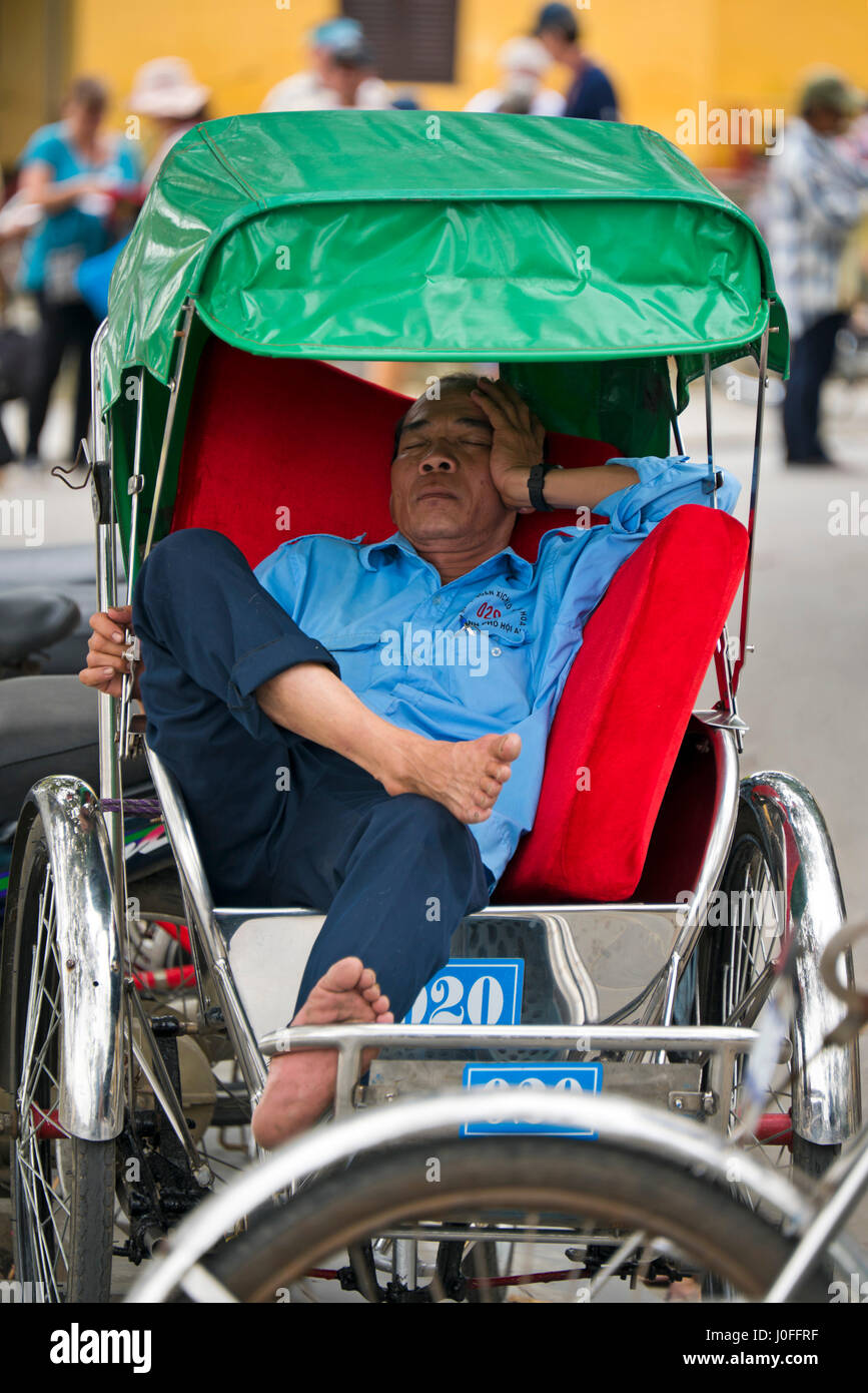 Vertical view of a cyclo driver relaxing in Hoi An, Vietnam Stock Photo ...