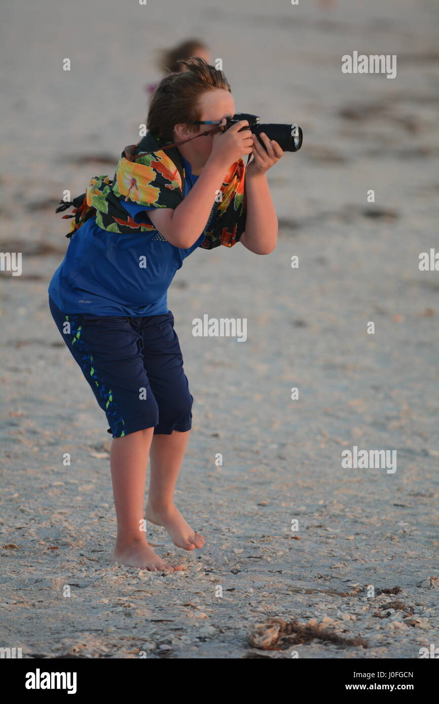 young boy with camera shooting sunset Stock Photo - Alamy