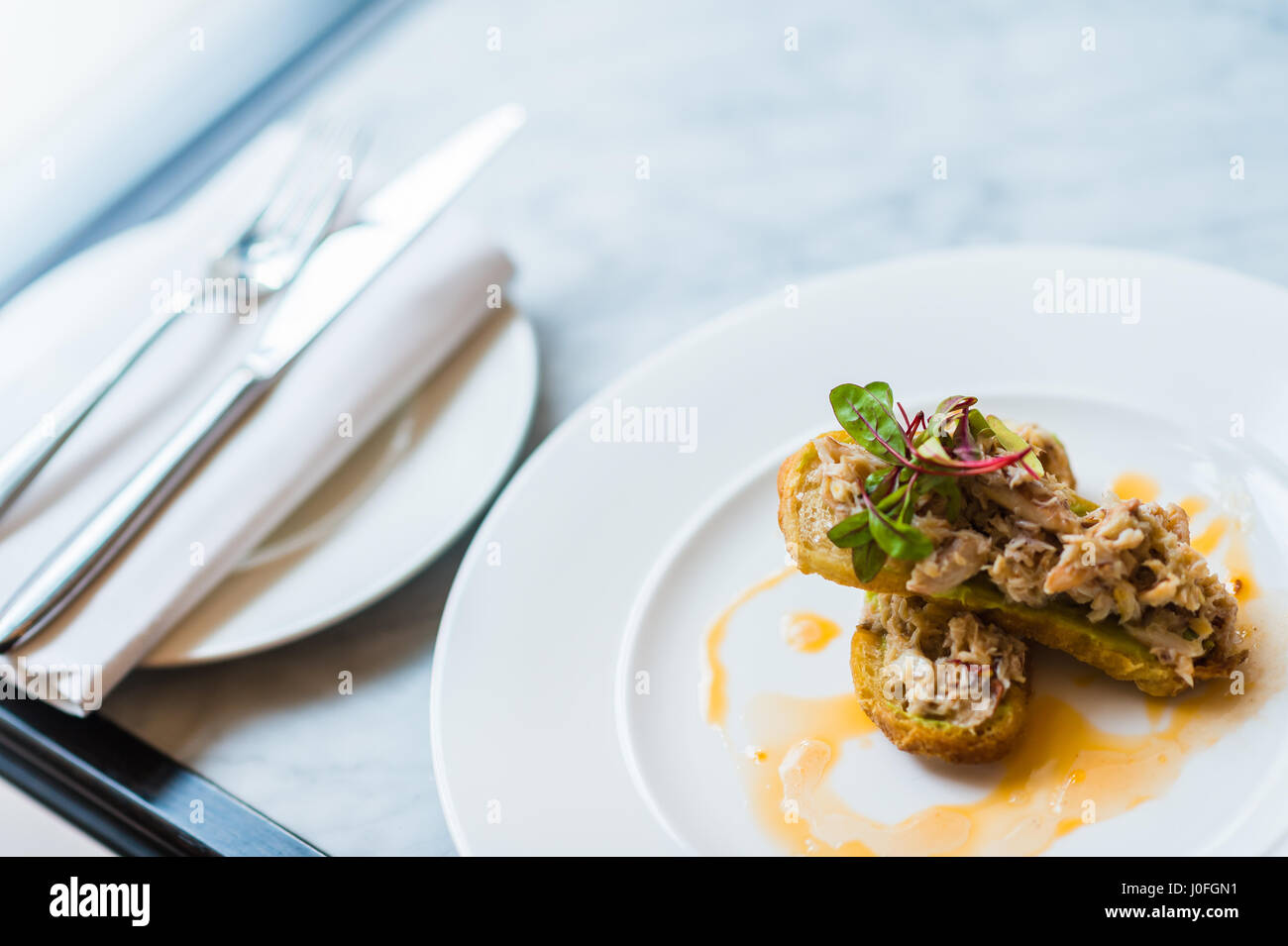 A fish toast starter on a plate in a restaurant Stock Photo - Alamy